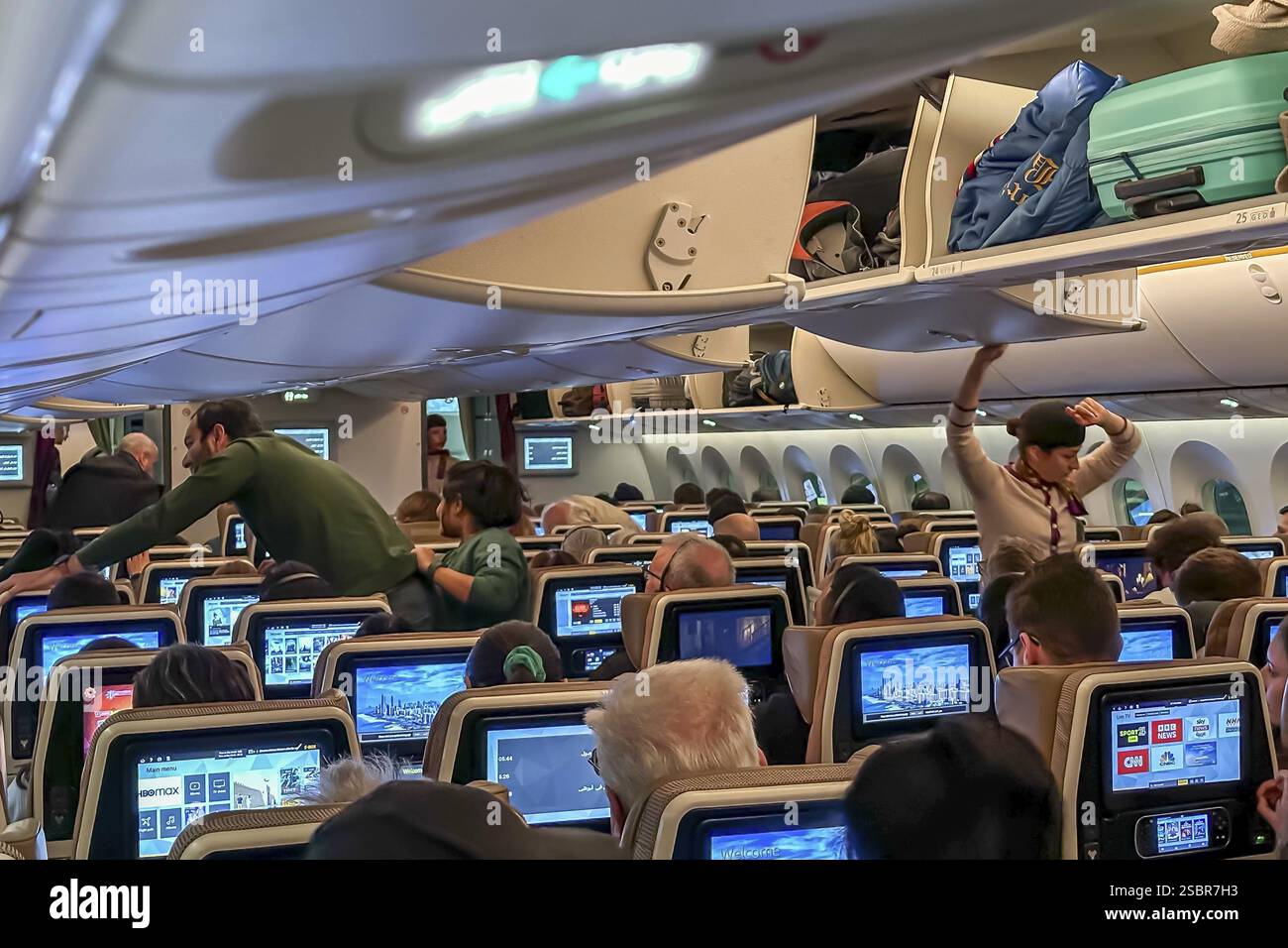 Etihad airline aircraft, interior, rows of seats with passengers ...