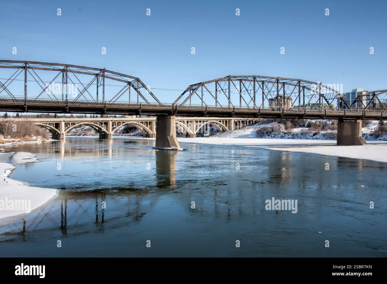 A bridge over a river with a reflection of the bridge in the water. The ...