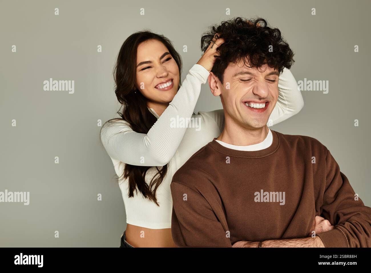 Two young friends share a joyful moment featuring modern styles and ...