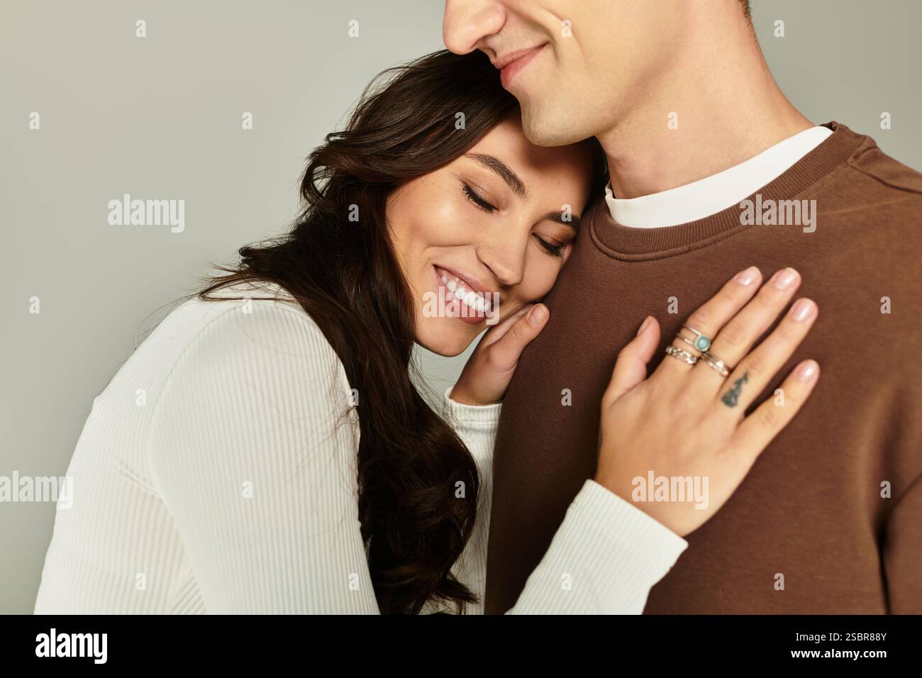 Young couple embraces lovingly, showcasing their stylish outfits and ...