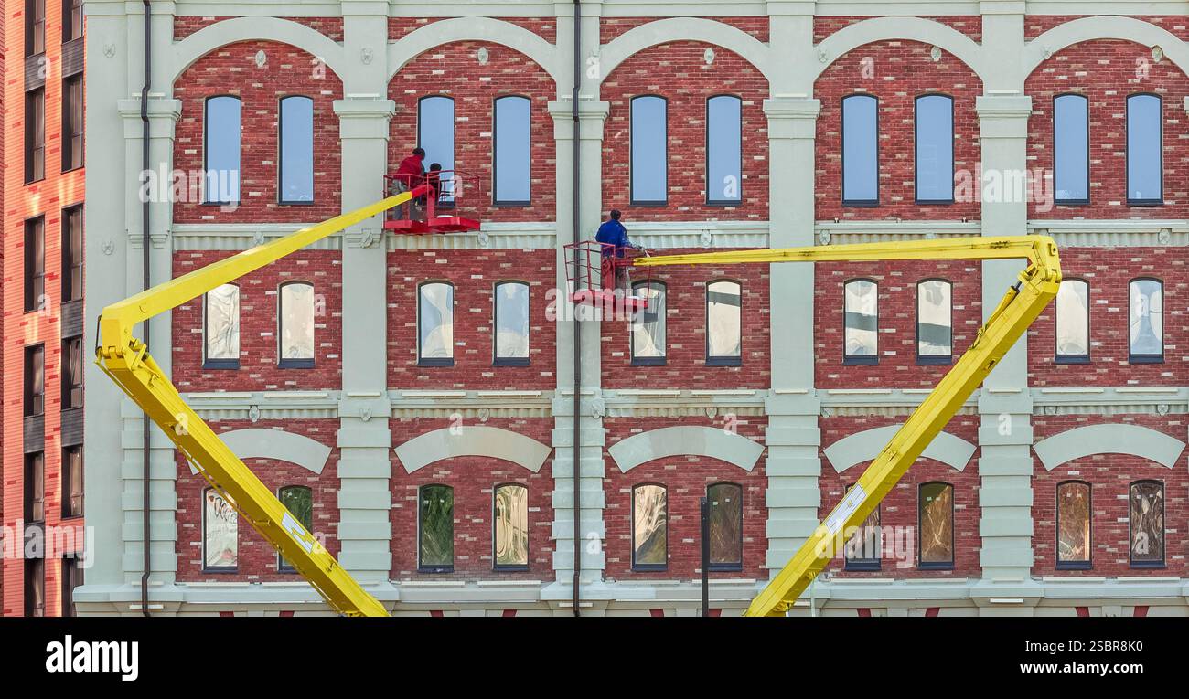 Workers Cleaning Windows and Renovating Building Facade Using a ...