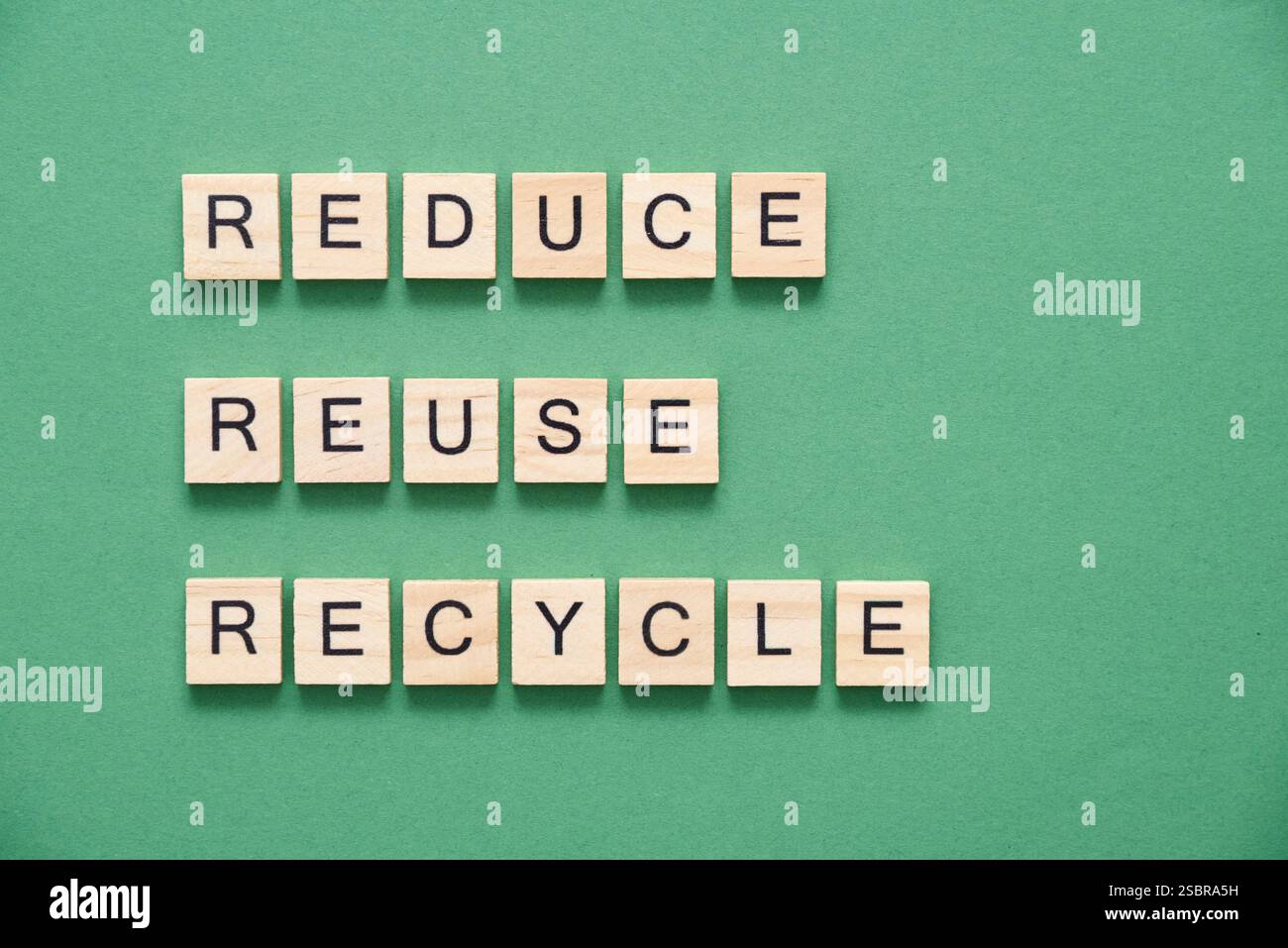 Wooden pieces with letters form, on a green background, a message of ...