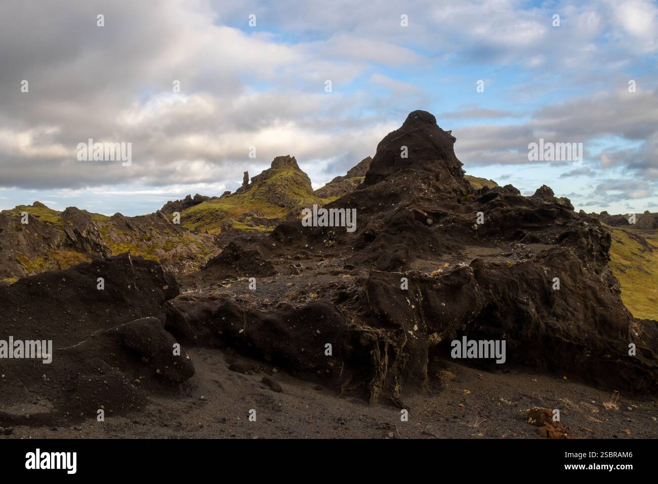 Detail of volcanic rocks of various shapes, partly covered by moss and ...