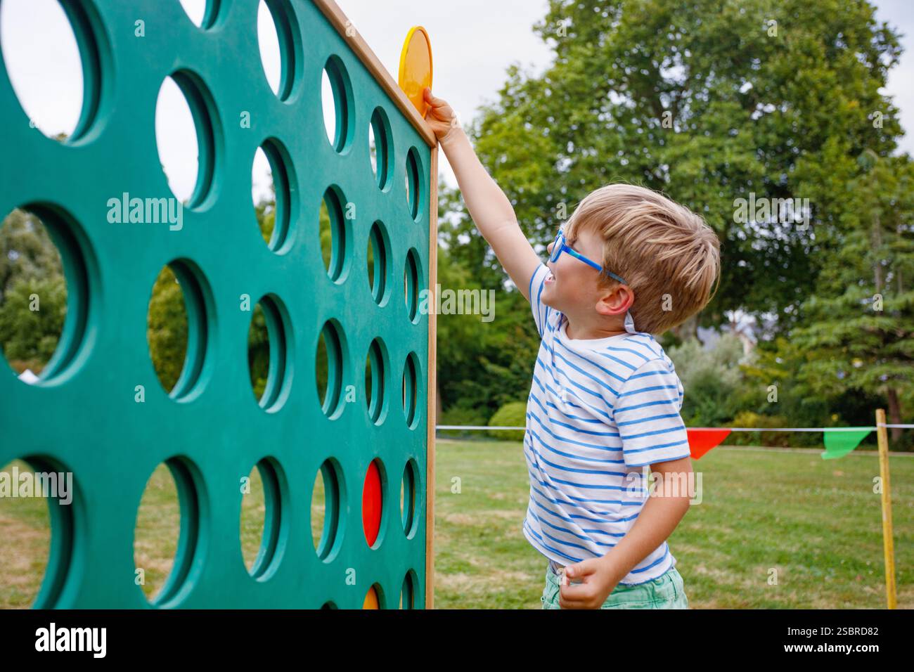 Boy plays giant Connect Four outdoors, enjoying the fun game Stock ...