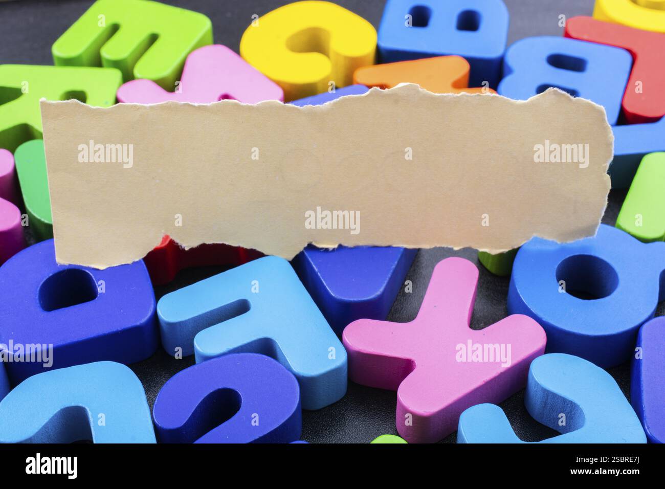 Torn paper placed on Colorful Letters of Alphabet Stock Photo - Alamy