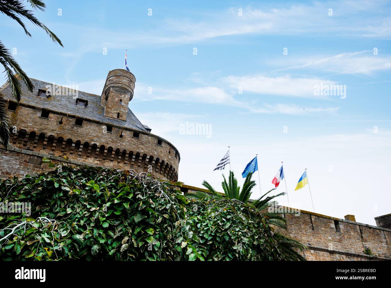 Flags wave atop a historic stone castle at Saint-Malo, France Stock ...