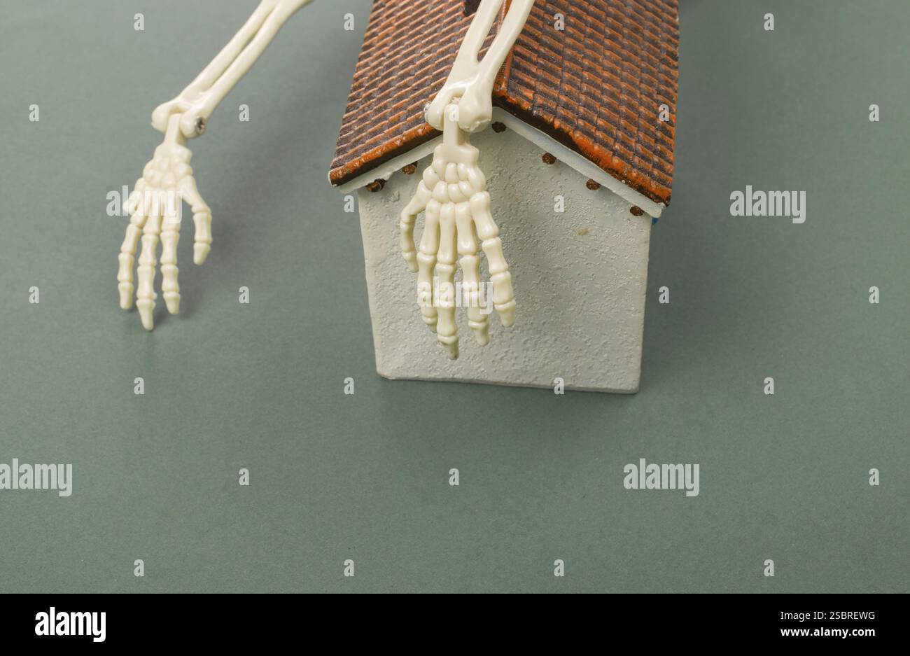 Small model house and human skeleton hand as horror concept Stock Photo ...
