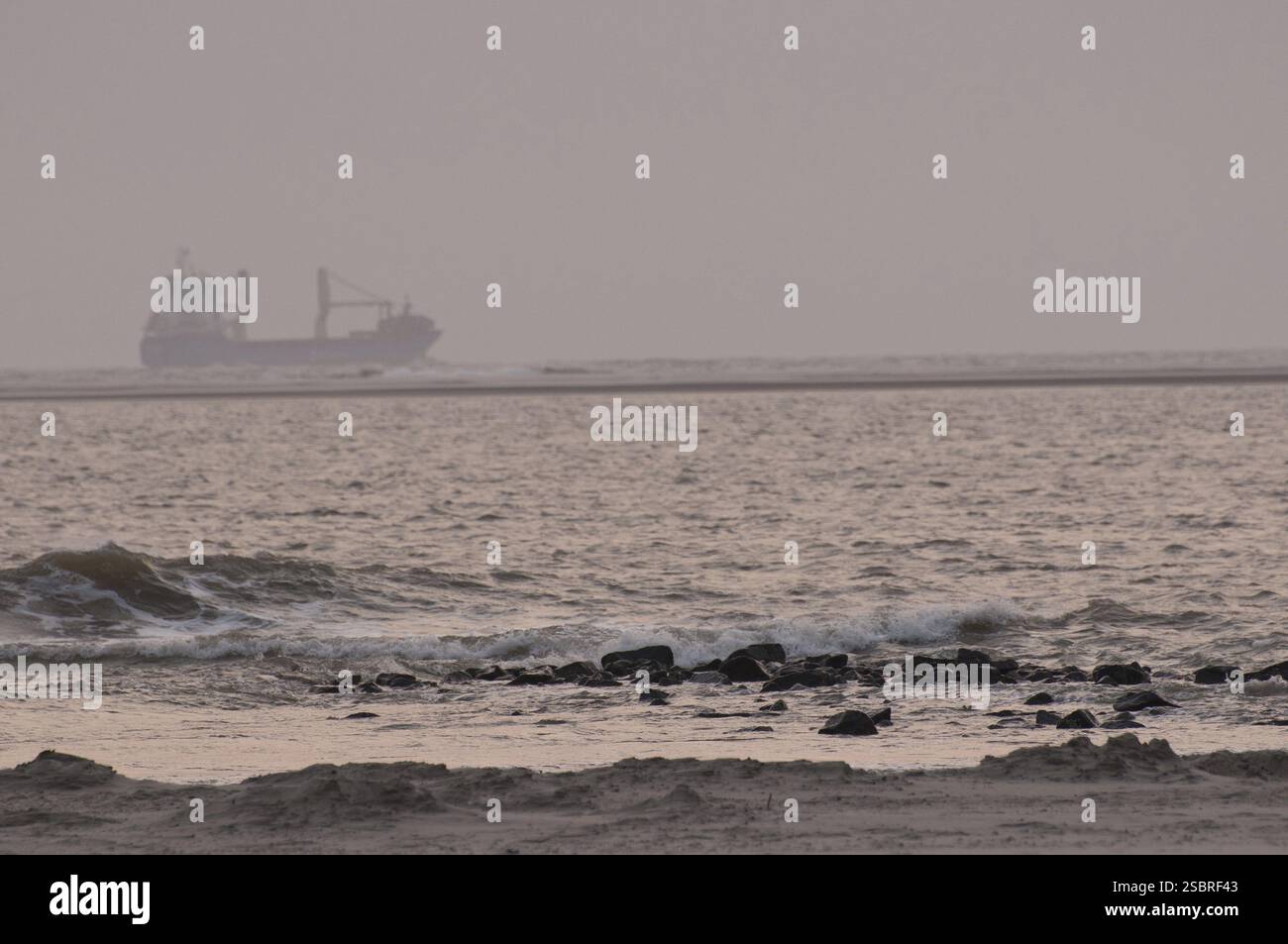 Ship sailing on the horizon, waves breaking on the beach, Borkum, north ...