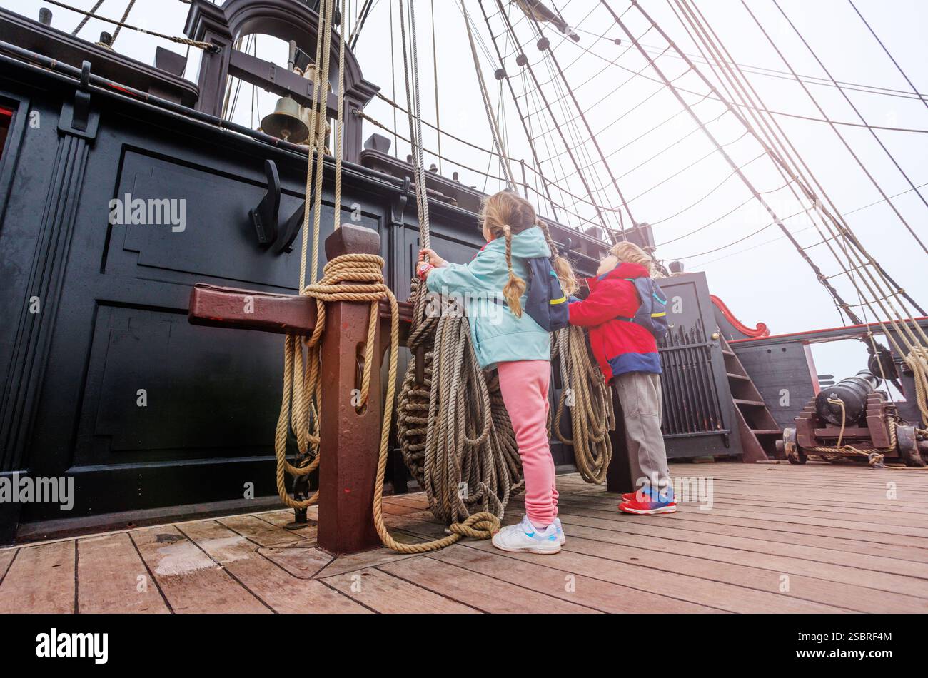 Energetic kids enjoy tugging a ropes on deck of old pirate ship Stock ...