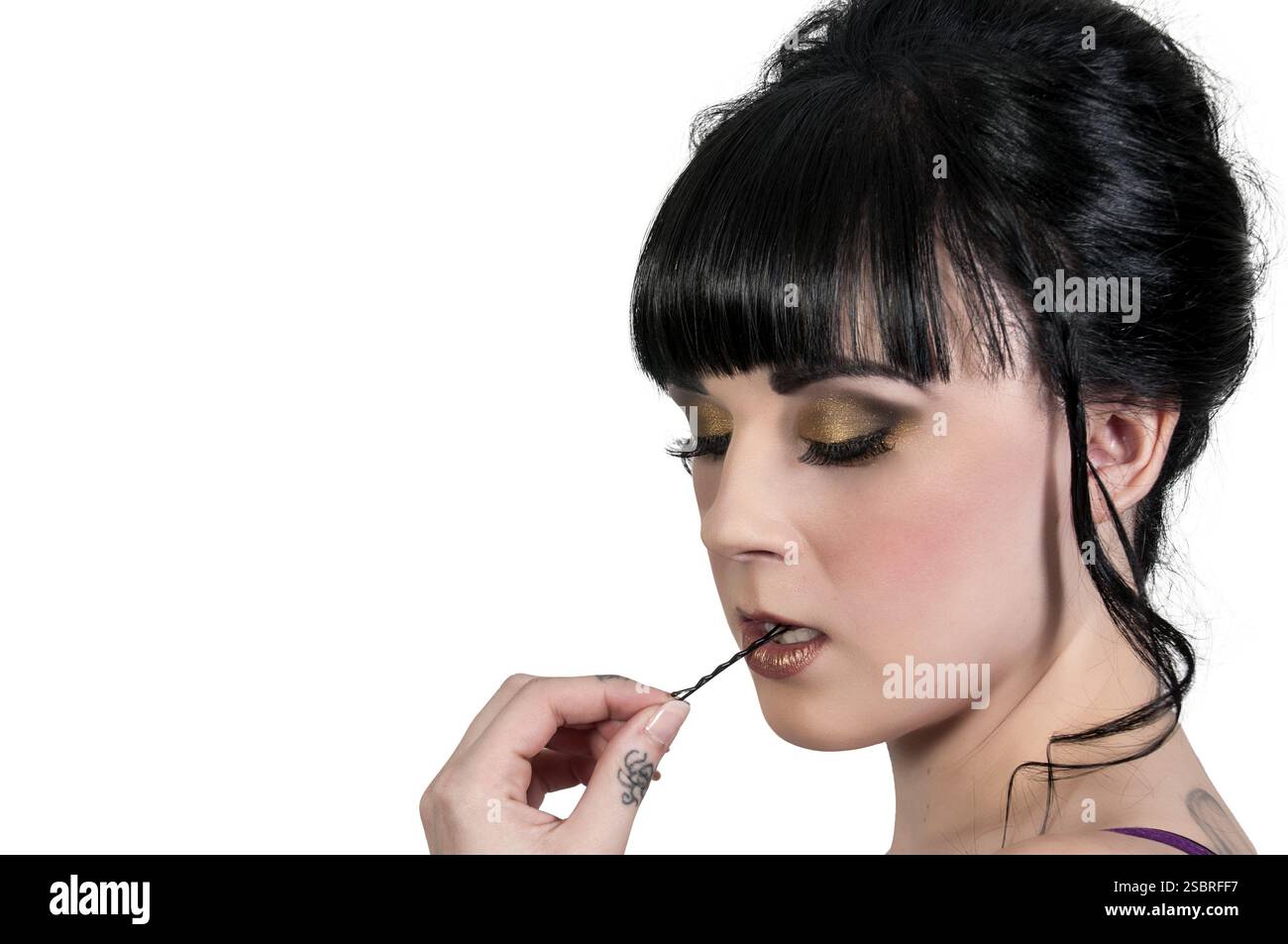 Beautiful woman biting a bobby pin before putting it into her hair ...