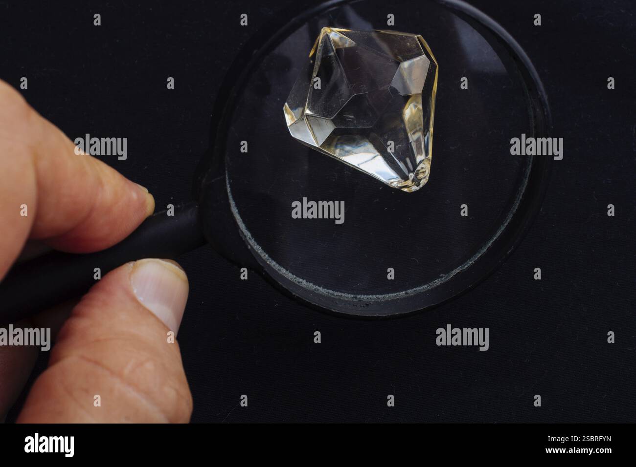 Magnifying glass and exploring the fake diamod glass Stock Photo - Alamy