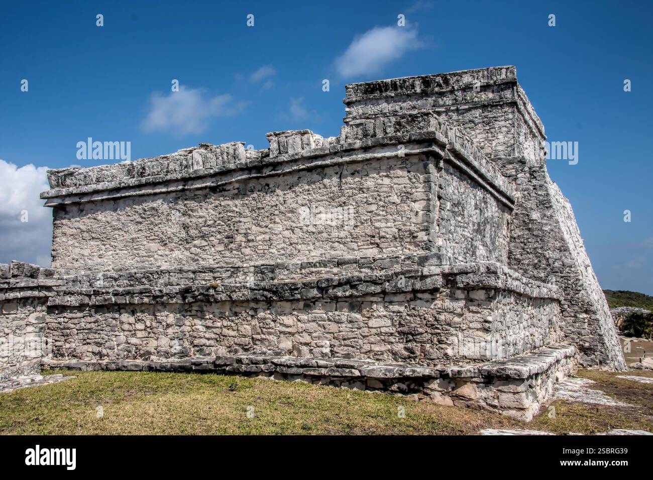 A large stone building with a white roof. The building is surrounded by ...