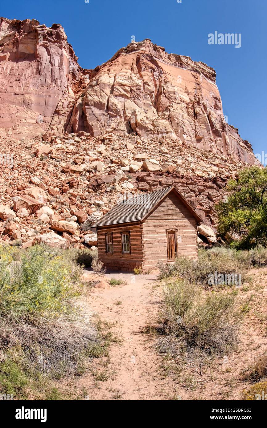 A small cabin is in the middle of a desert. The cabin is made of wood ...