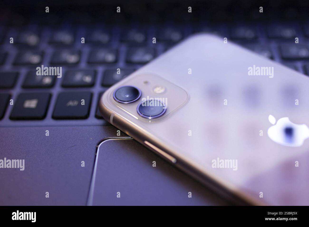 Focused view on smartphone camera with keyboard backdrop, reflecting ...