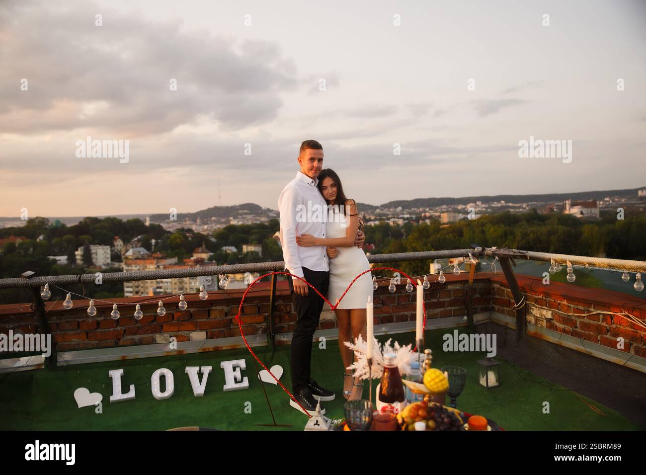 Couple celebrates love with a romantic rooftop dinner at sunset in an ...