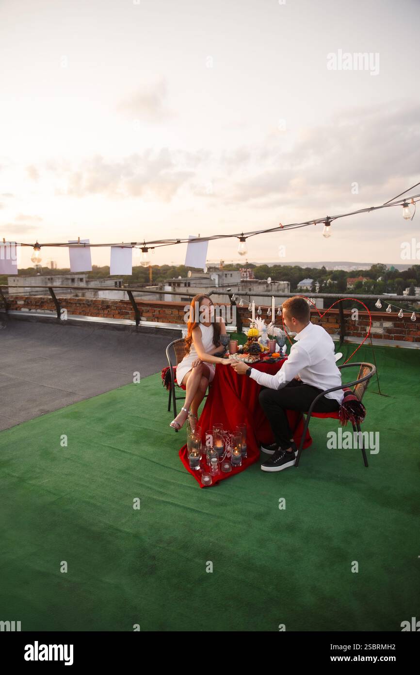Romantic rooftop dinner at sunset overlooking the city skyline with a ...