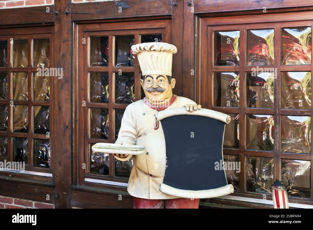 Menu board with statue of chef outdoors Stock Photo - Alamy