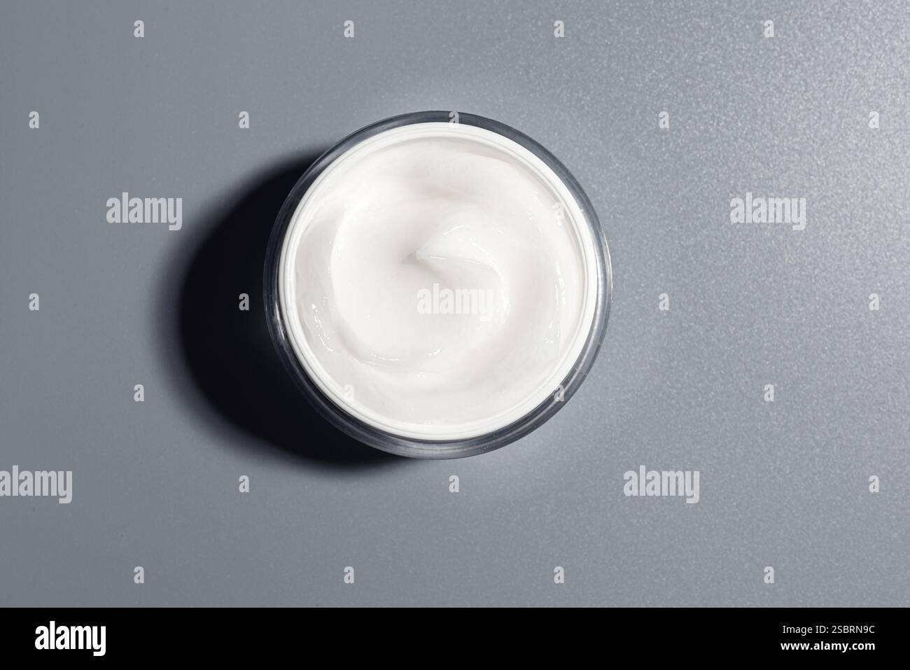 Open cream jar on neutral grey background, top view, close up. Rich ...