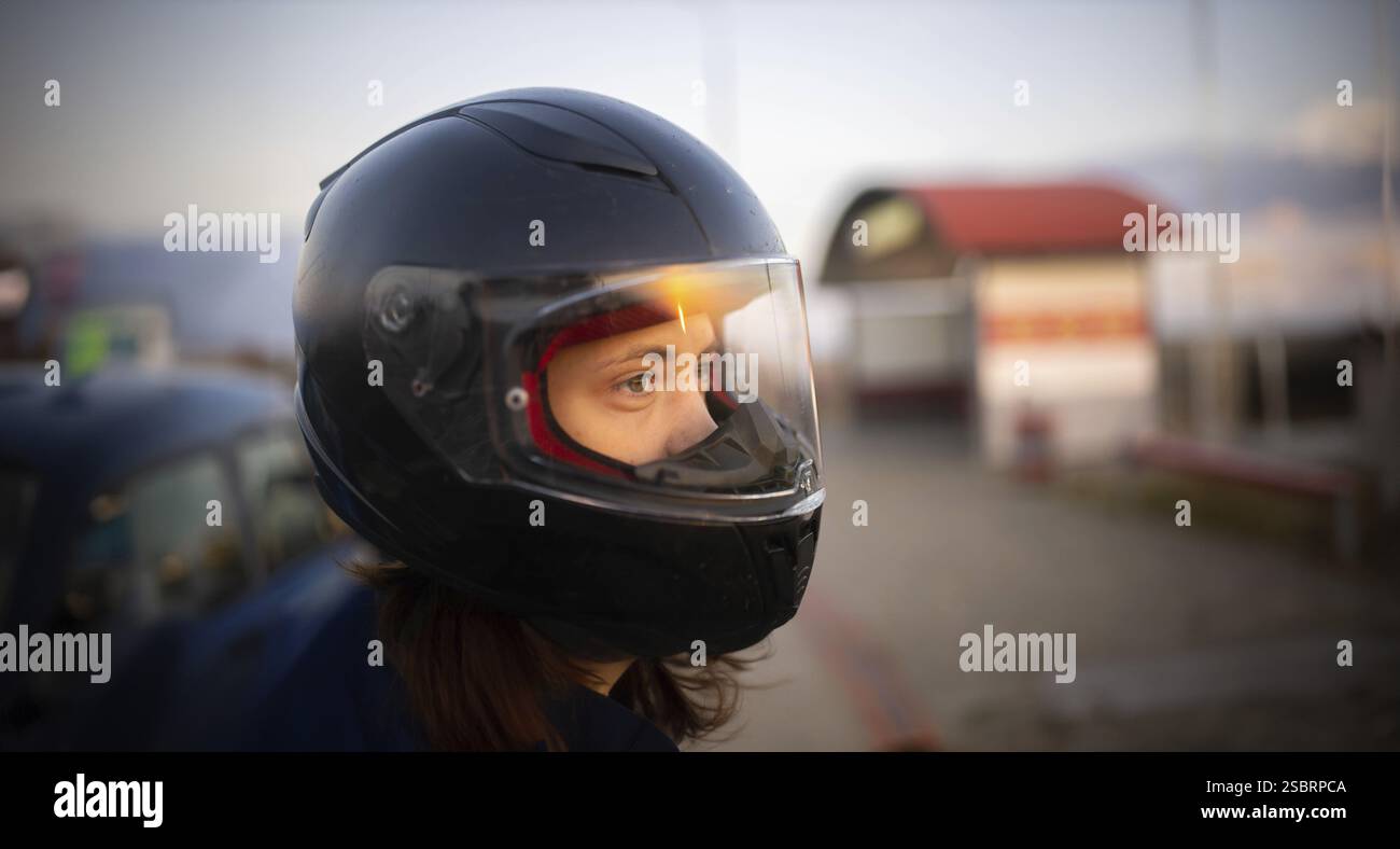 A woman in a racing helmet gazes intensely, the backdrop blending ...