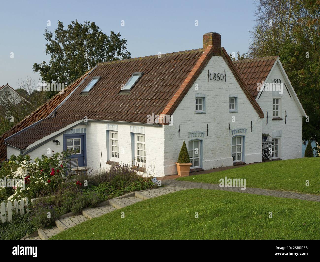 Historic white brick house from 1850 with colourful garden and red ...