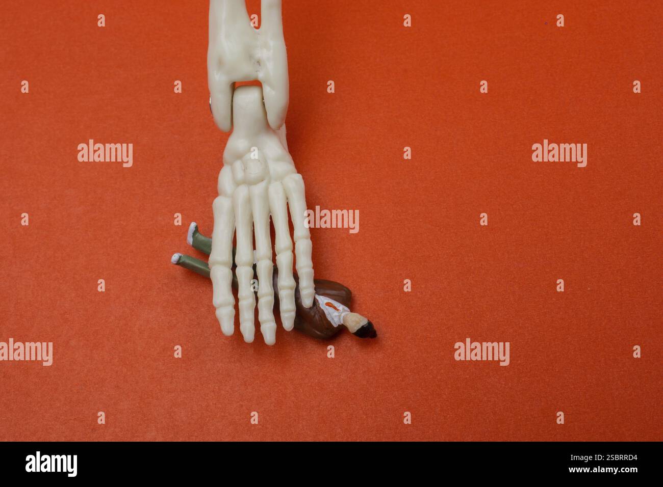 Skeleton hand pressing on man figurine on red . Death concept Stock ...