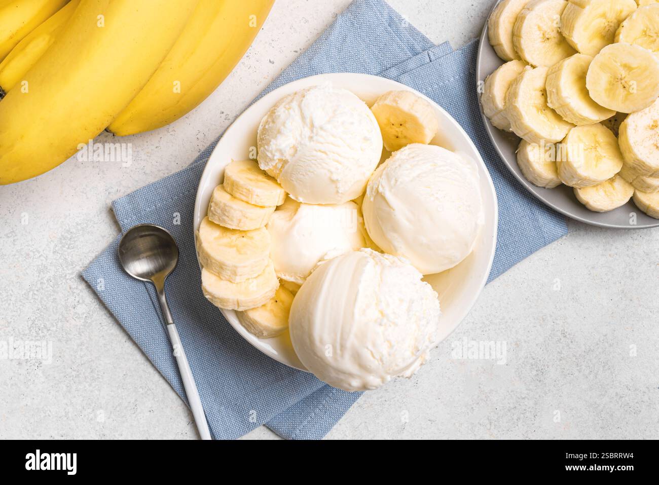 Ice cream scoops and banana slices in bowl close up, top view. Healthy ...