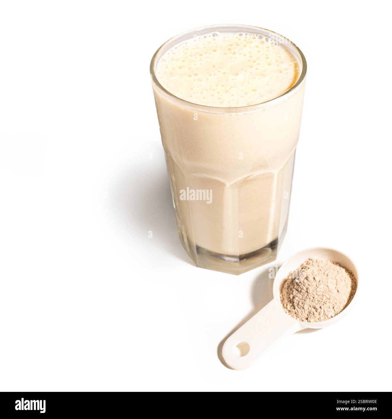 Glass with protein shake and powder in scoop isolated on white ...