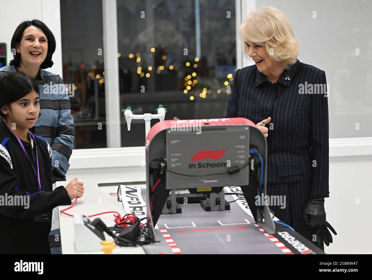 Queen Camilla races with Mahira, 11, as Dr Vanessa Ogden (left), CEO of ...