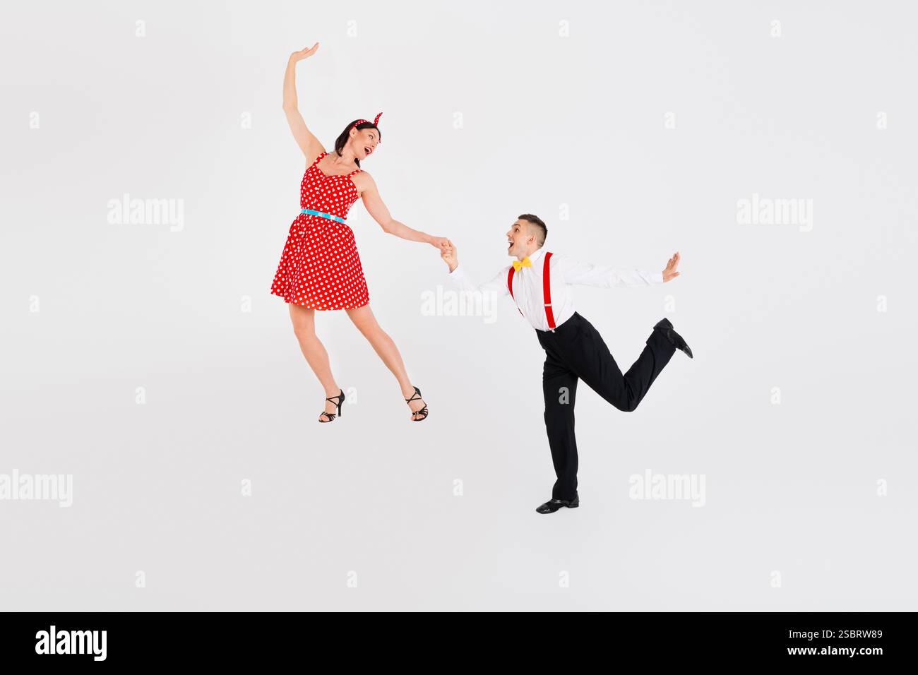 Photo of cheerful positive couple dancers learning samba dance ...