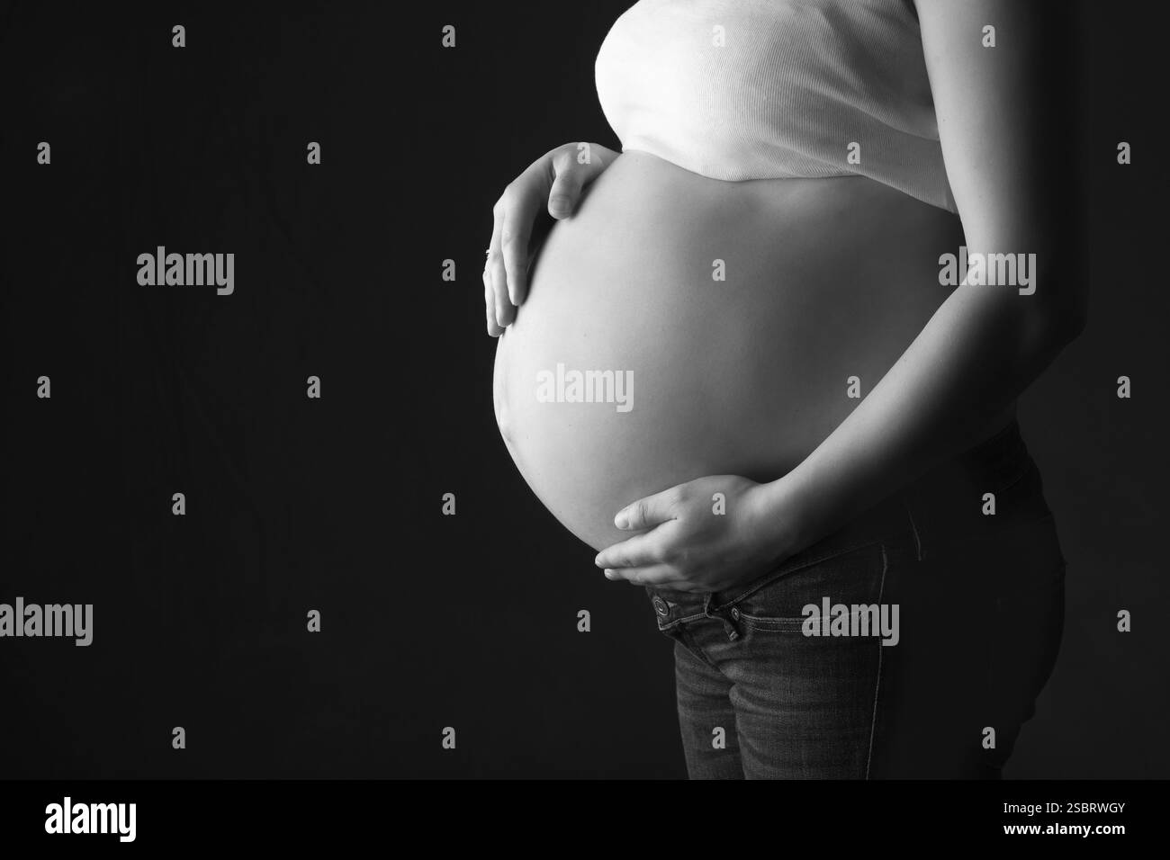 Pregnant woman, expectant mother on black background, close-up of ...