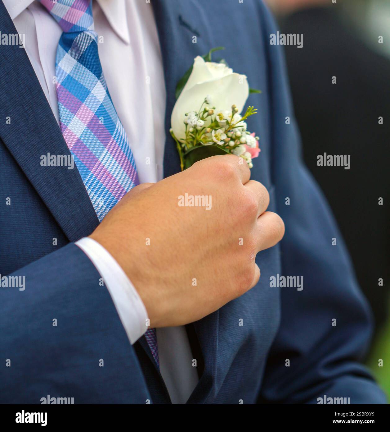 A man fastening a boutonnière to the lapel of his jacket Stock Photo ...