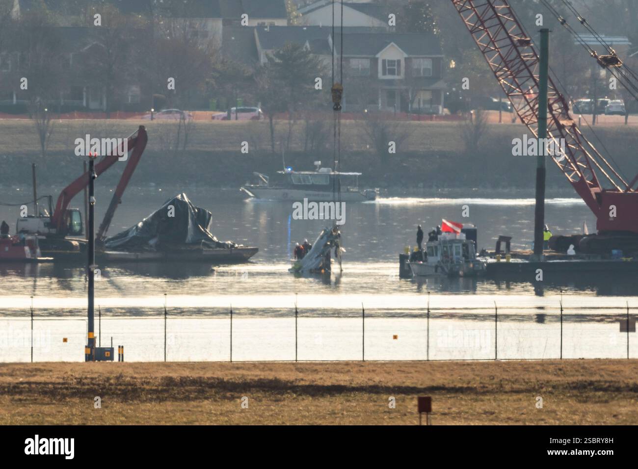 Salvage crews lift a piece of wreckage from the water at the site in the Potomac River of a mid ...