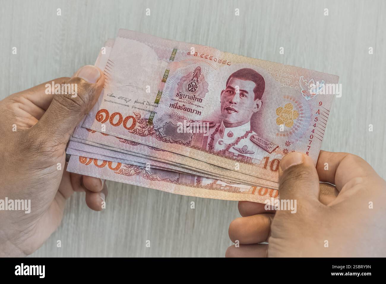Man holding Thai baht in his hands. Thai baht banknotes cash money ...