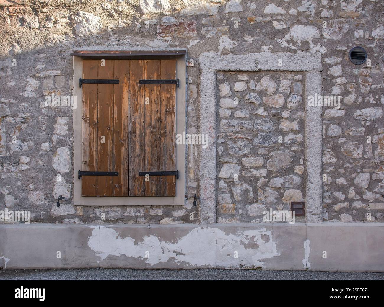 A wooden shuttered window and blind door in a traditional stone house ...