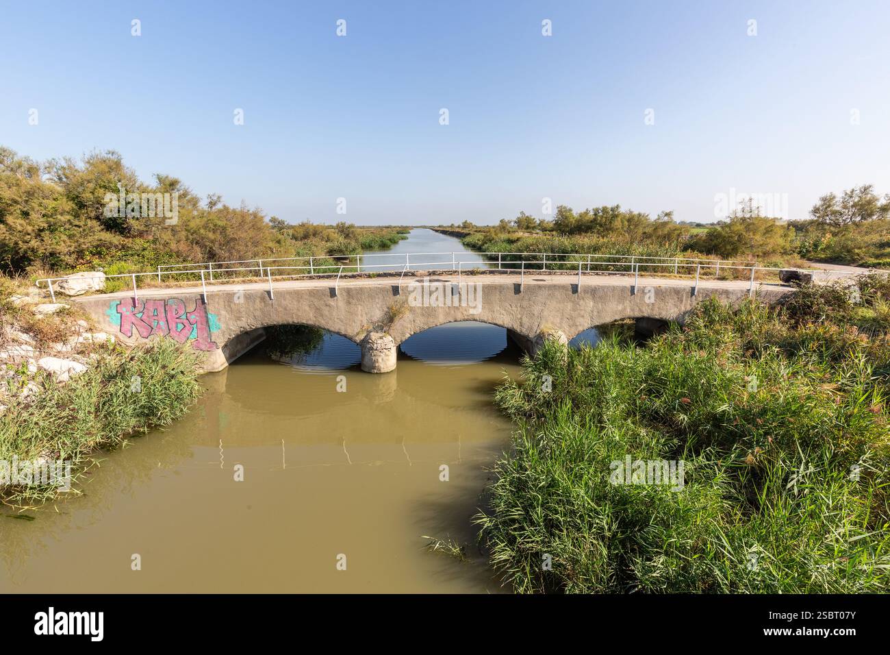Drainage channel spanned by a bridge in the Camargue plain Stock Photo ...