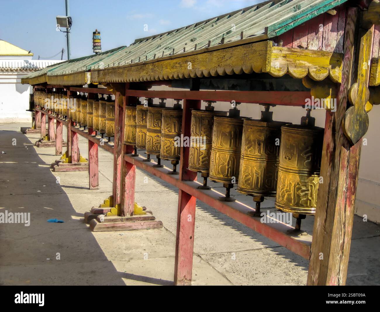 A row of bells hanging from a wooden structure. The bells are gold and ...