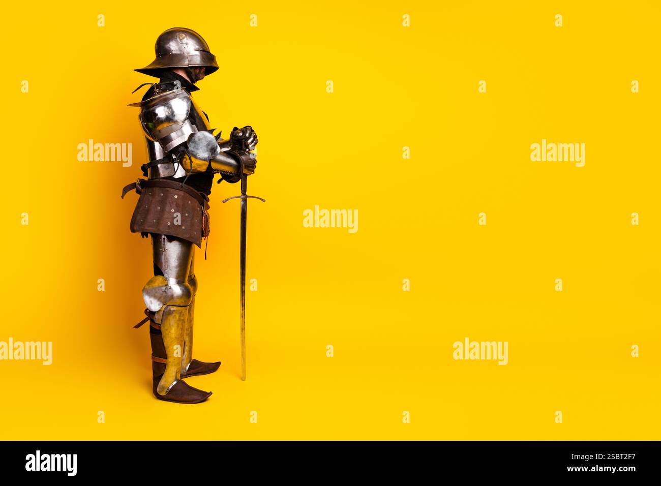 Side profile of an armored knight with sword against vibrant yellow ...