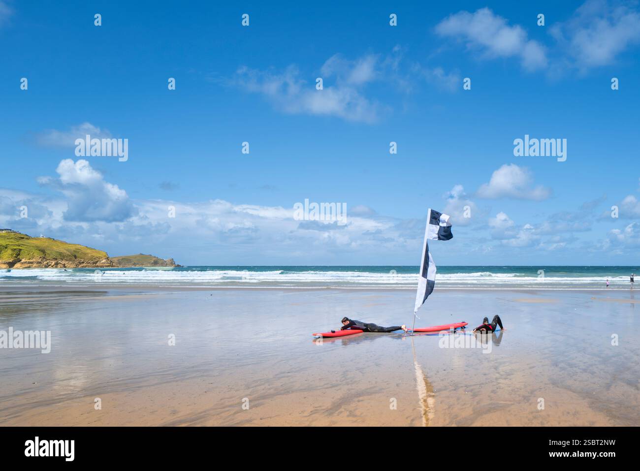 Two tired surfers taking a break from surfing and lying down next to ...