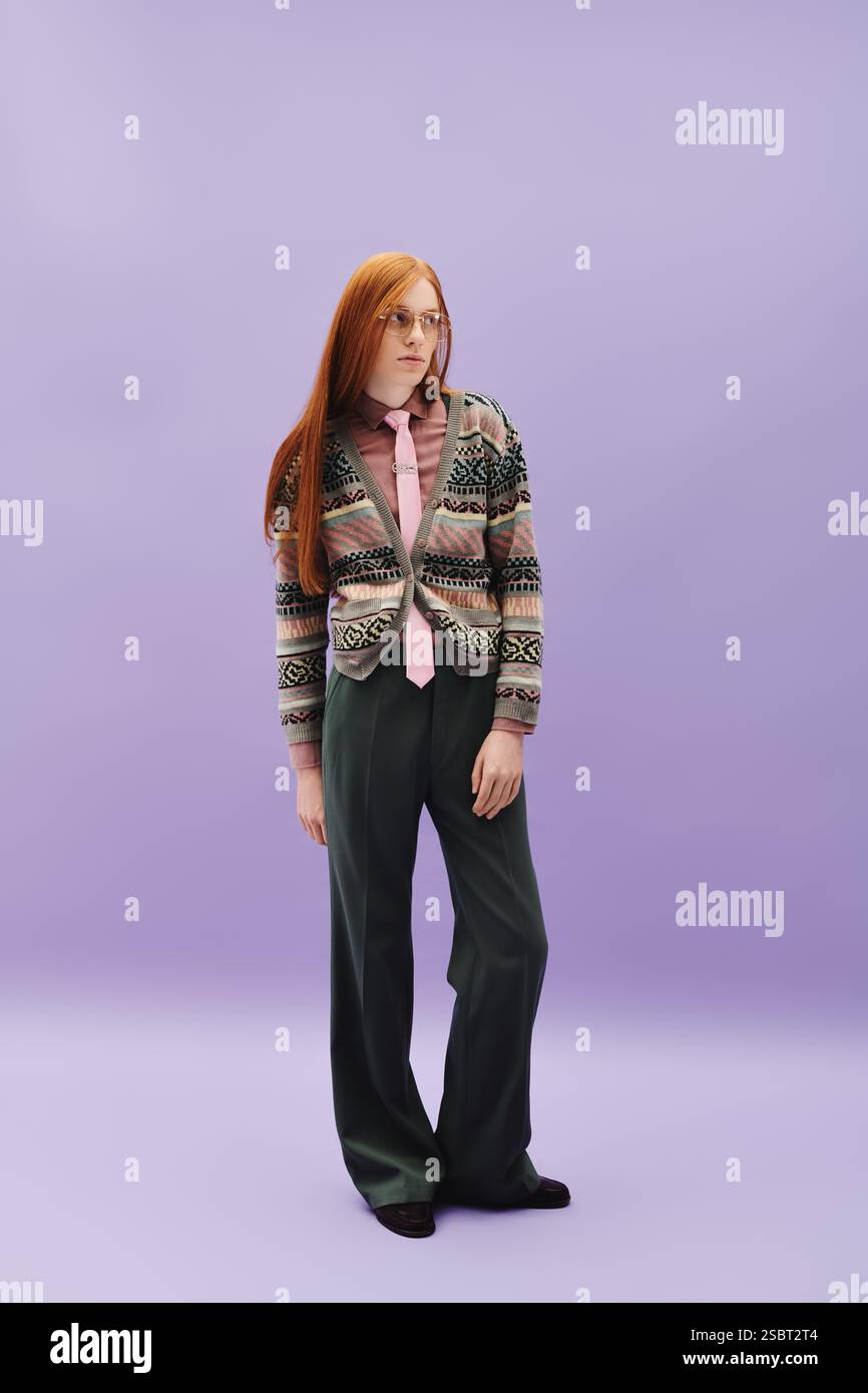 A young man with long red hair poses in a stylish outfit against a soft ...
