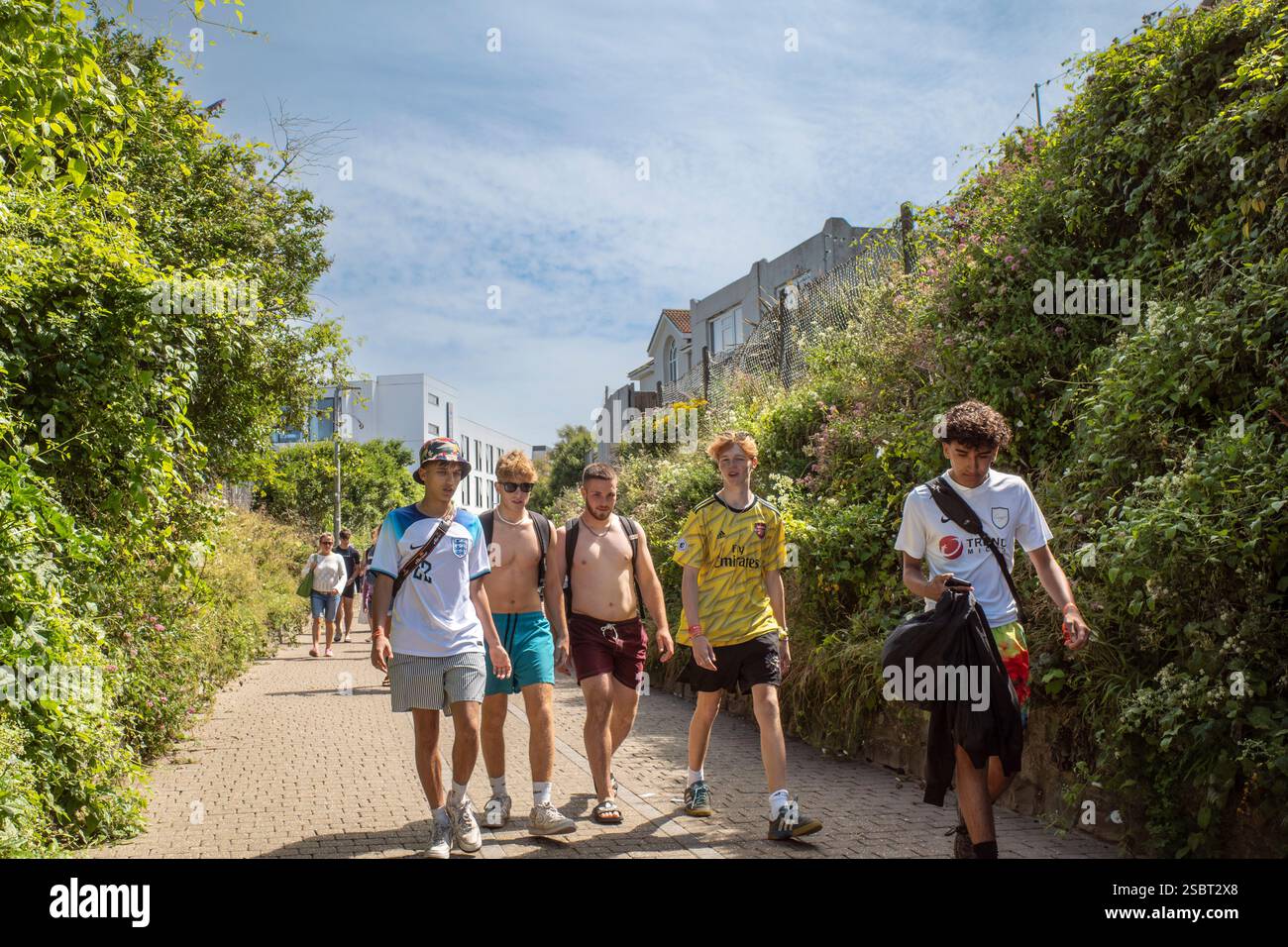 A group of young male holidaymakers visitors walking along the Tram ...