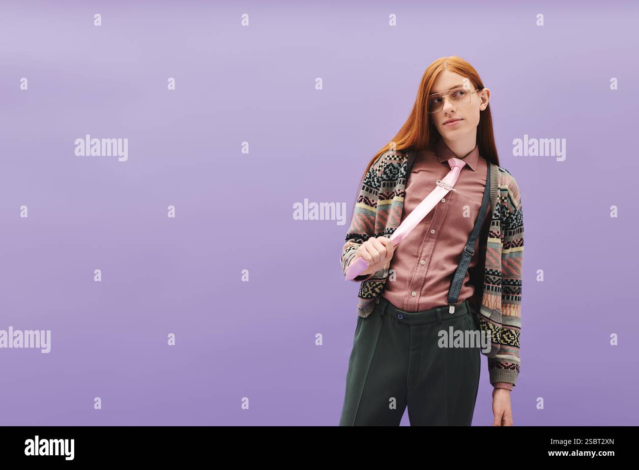 A stylish young man with long red hair poses confidently in a vibrant ...