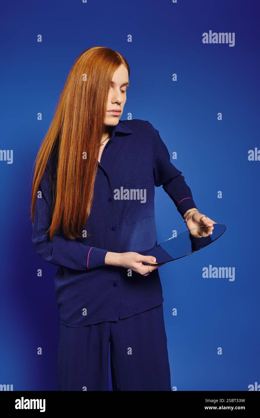A stylish queer person examines a unique reflective object, embodying ...