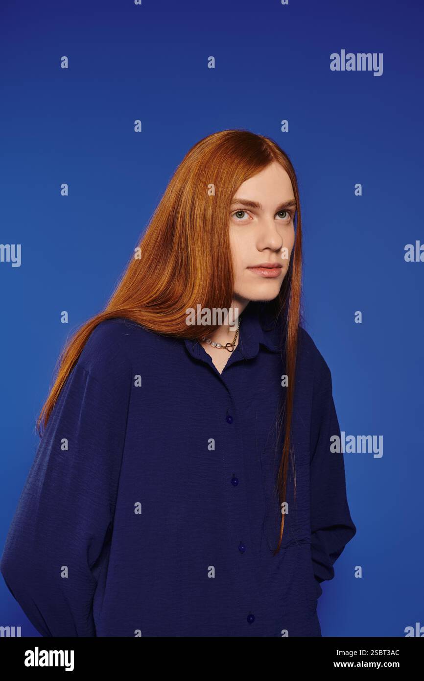 A young man with striking red hair confidently showcases his fashion in ...