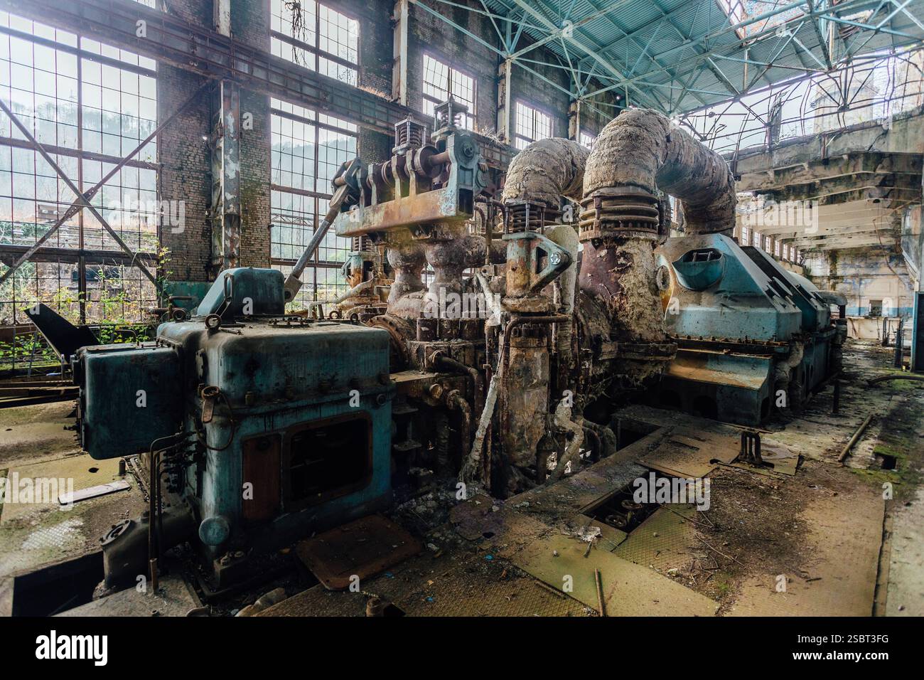 Rusty turbine generator. Abandoned destroyed by war and overgrown by ...
