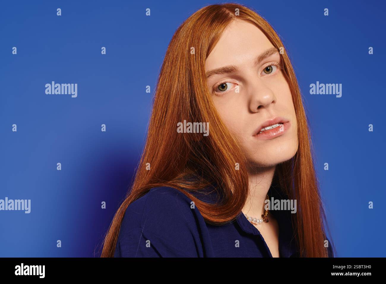 A stylish young queer man with long red hair embraces his self ...