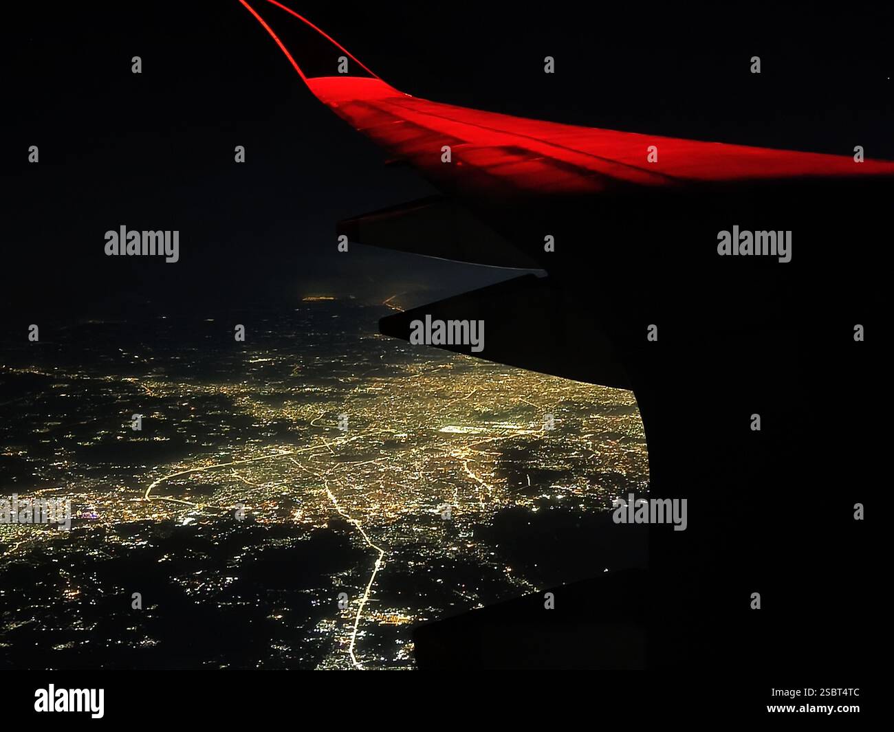 Aerial view of the city and sparkling lights at night from the airplane ...