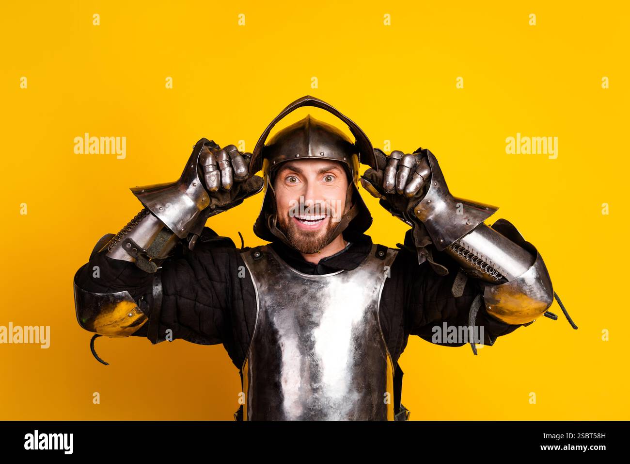 Happy knight in metallic armor poses on a vibrant yellow background in ...