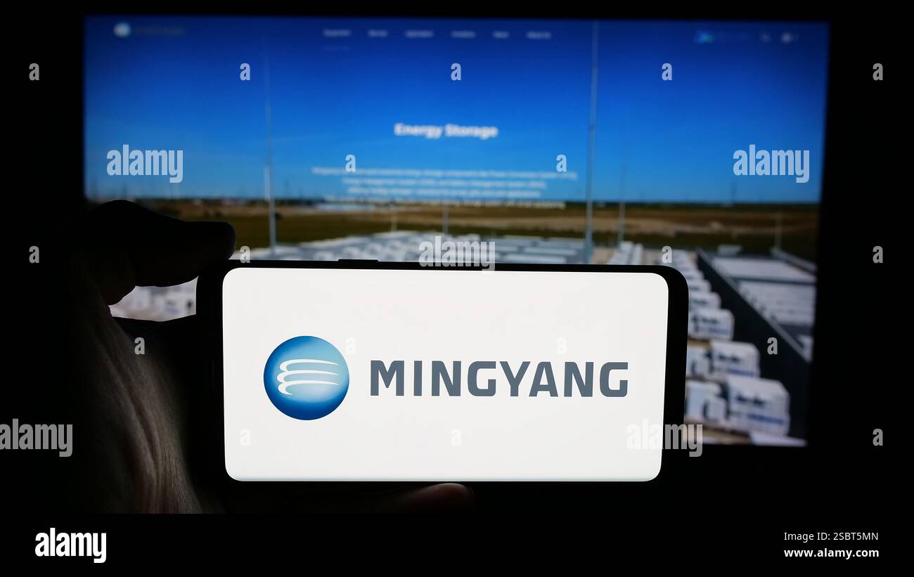 In this photo illustration, a person is holding a cellphone with the logo of Chinese company ...