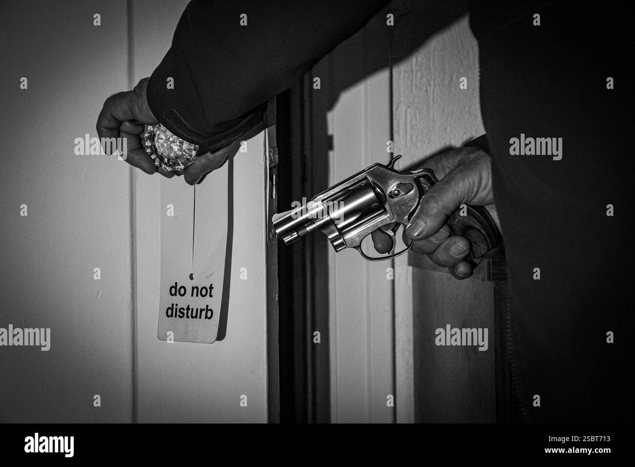 A man opening a door with a snub nose revolver in his right hand. Film ...