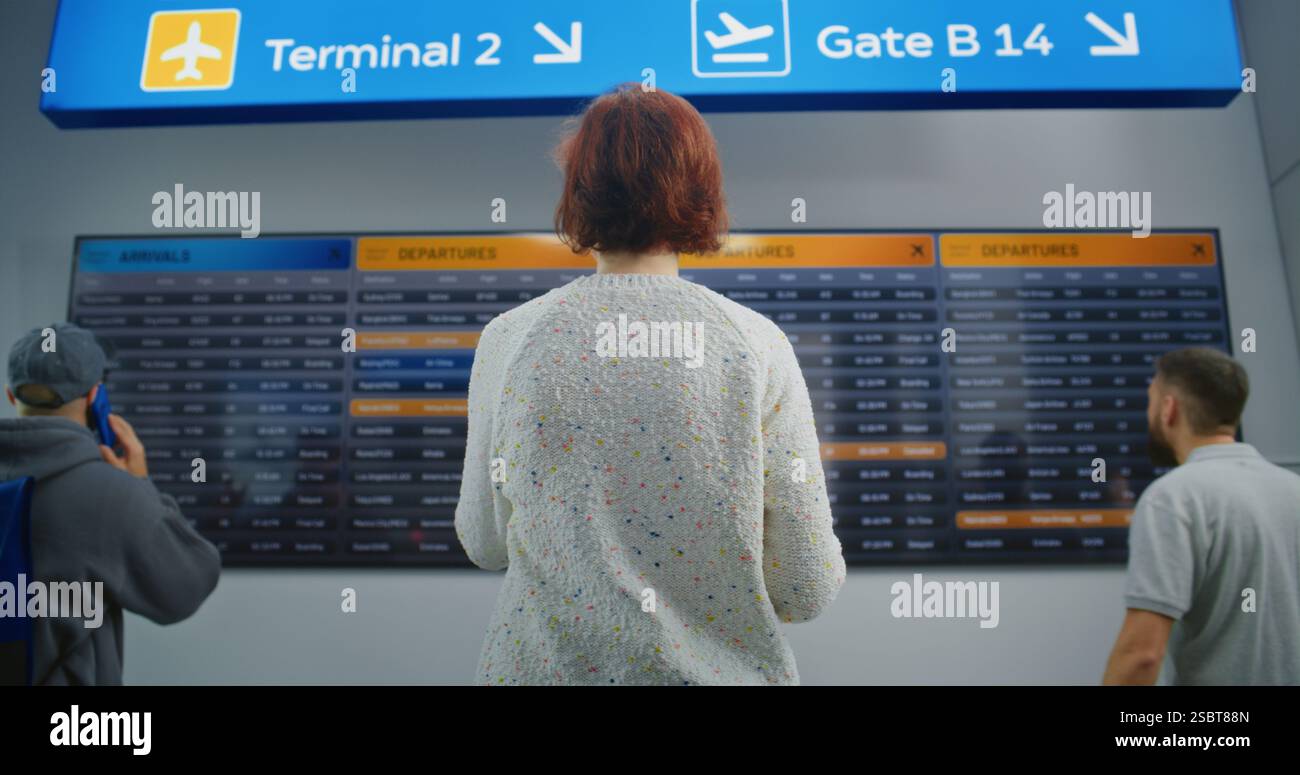 Airport Terminal: Back View of Woman with Suitcase Checking Departure ...